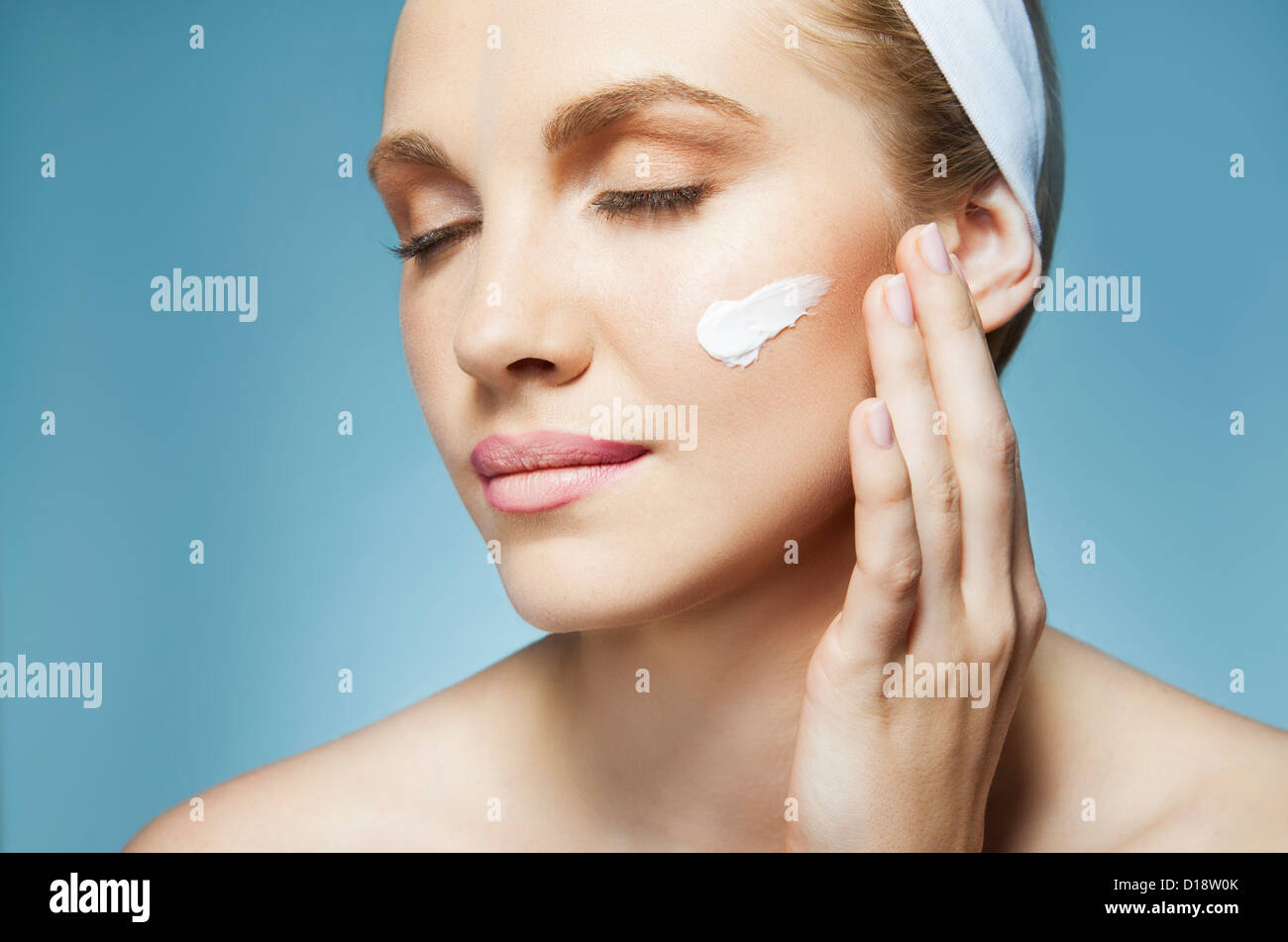 Woman applying moisturiser Stock Photo - Alamy