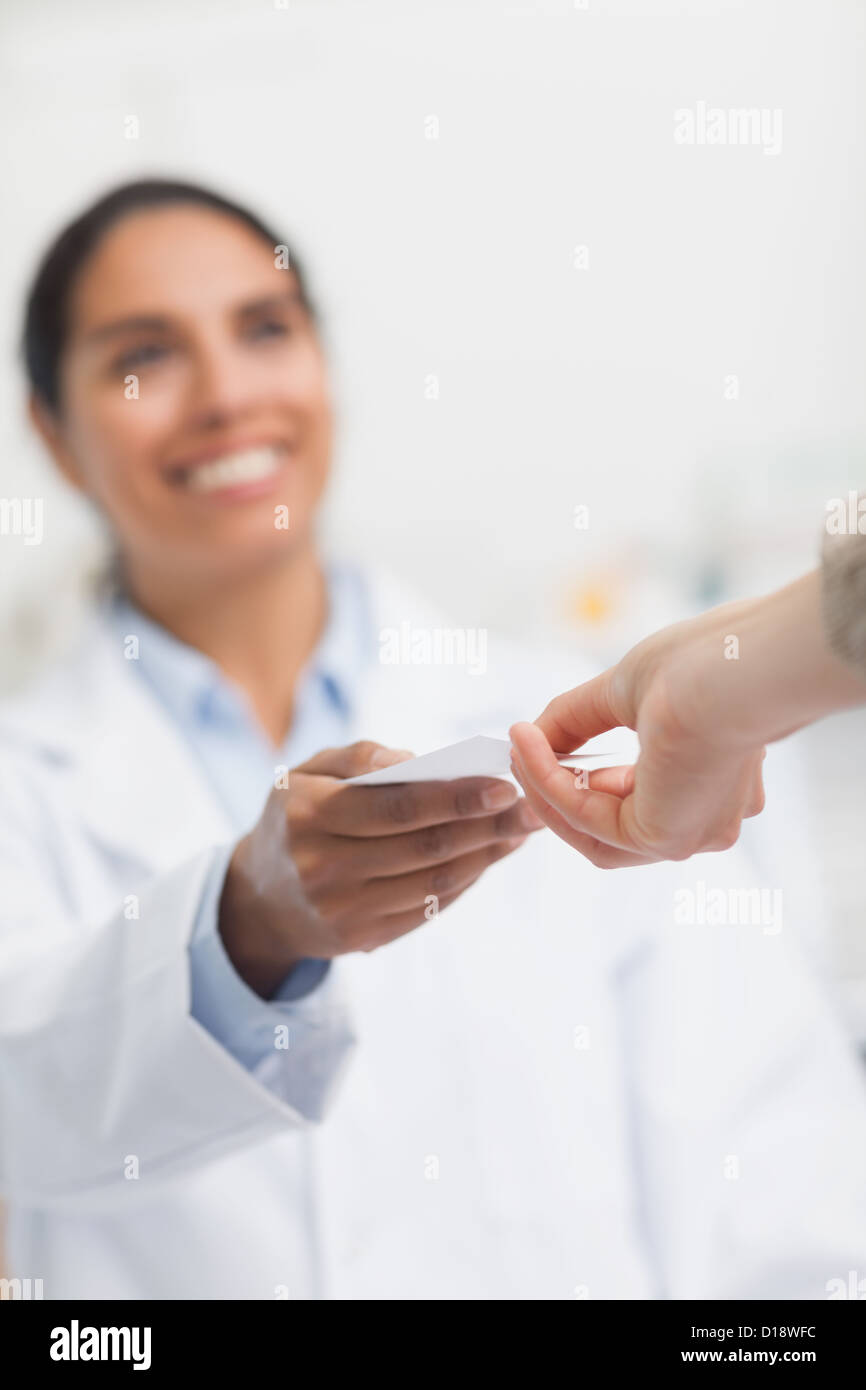 Happy pharmacist handing paper to a customer Stock Photo - Alamy