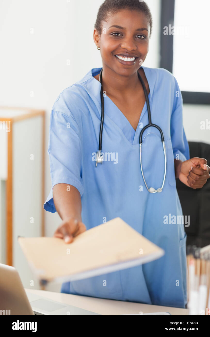 Nurse giving a folder at the reception Stock Photo - Alamy