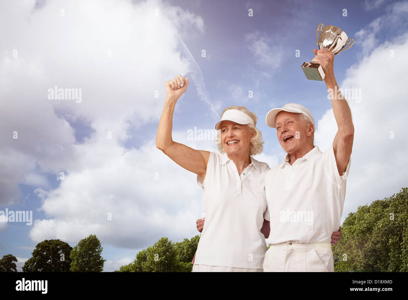 Senior couple holding tennis trophy and cheering Stock Photo - Alamy