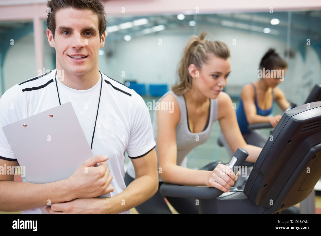 Spinning class instructor holding clipboard Stock Photo - Alamy