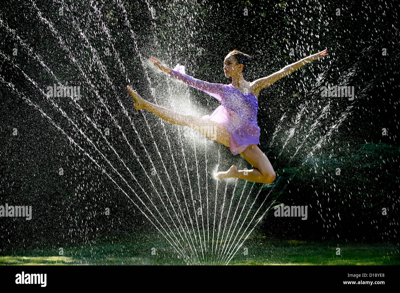 Ballerina jumping over water sprinkler Stock Photo - Alamy