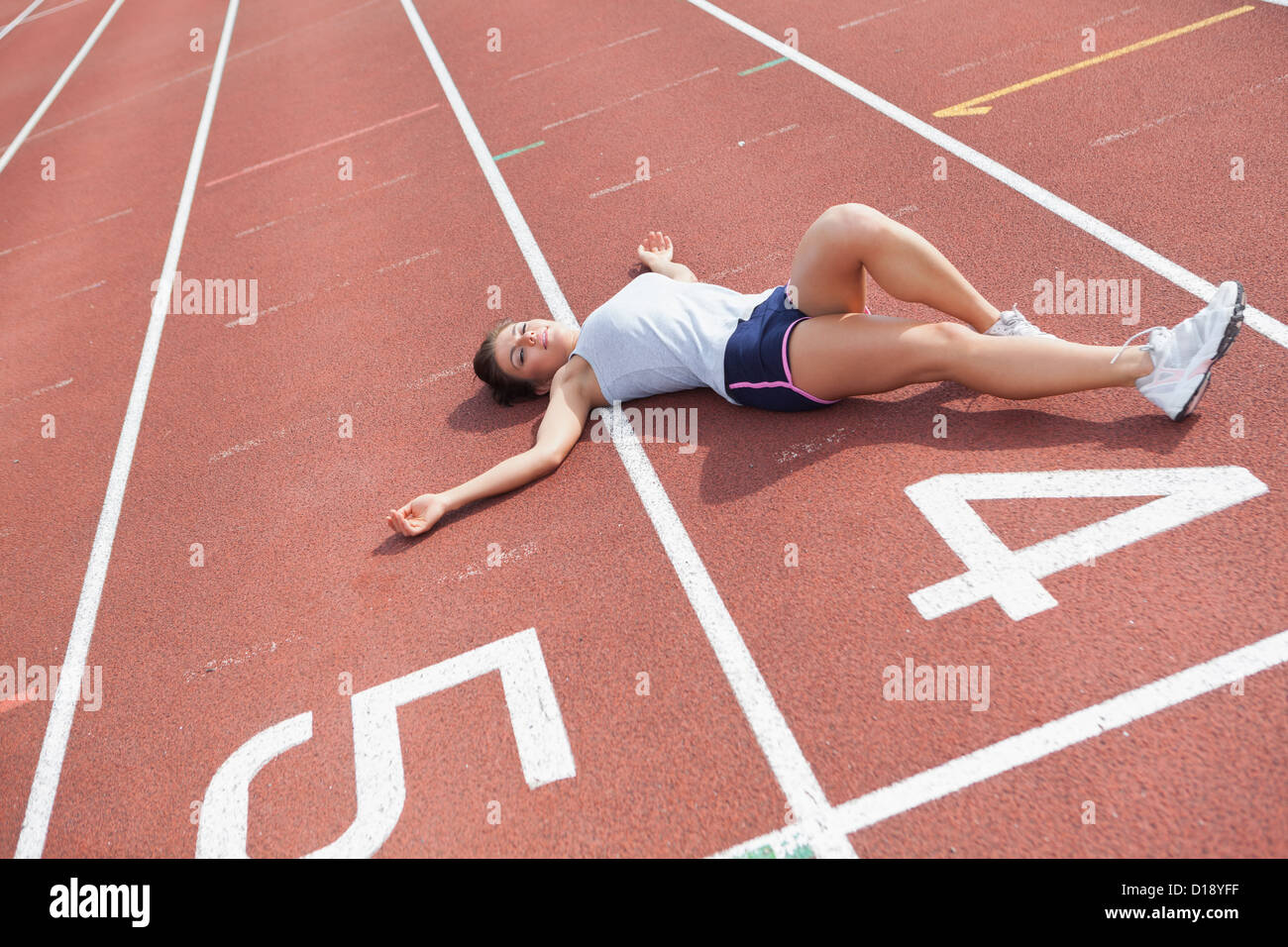 Woman taking break on track field Stock Photo - Alamy