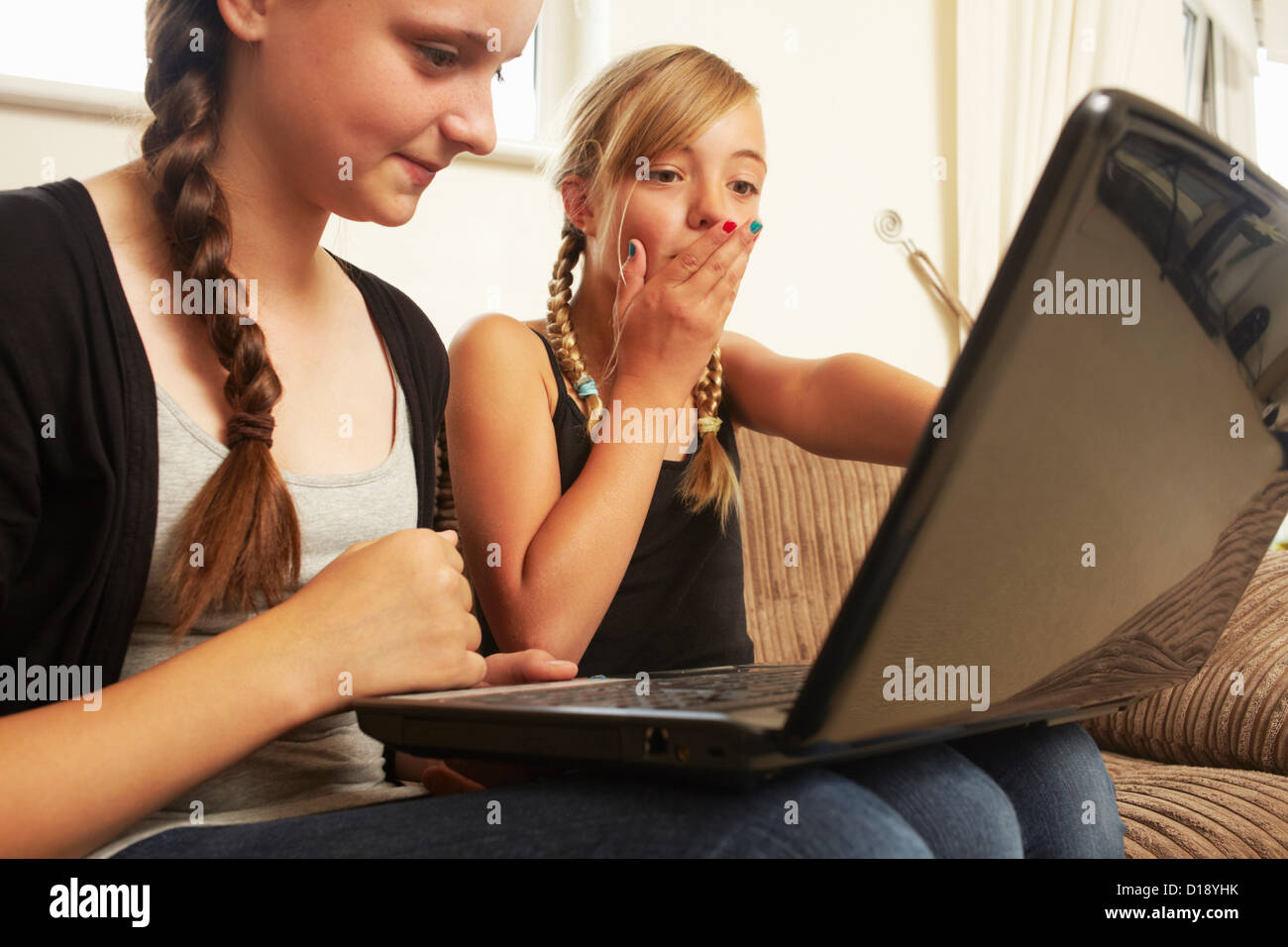 Two girls using laptop Stock Photo - Alamy
