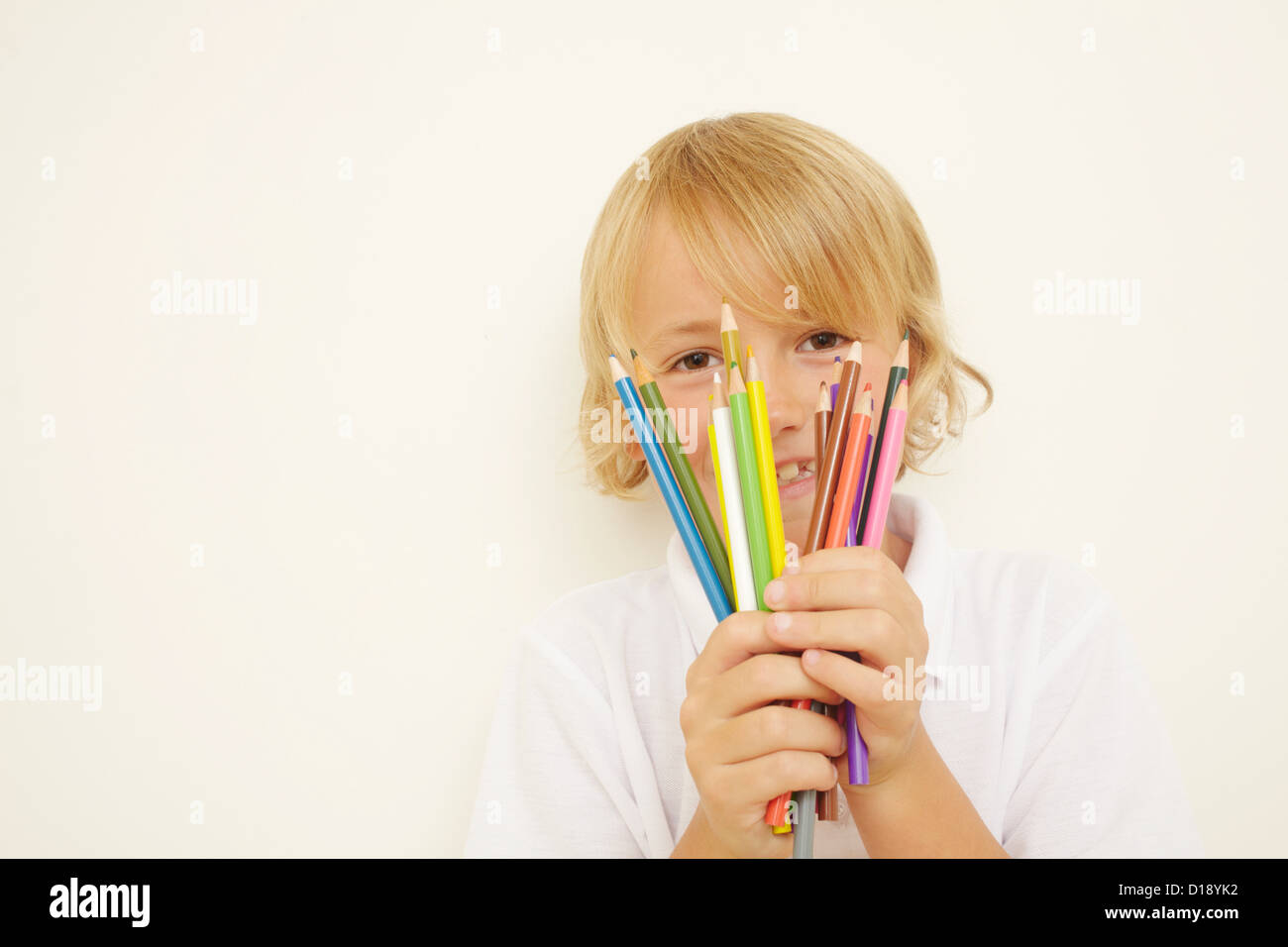 Schoolboy holding bunch of colouring pencils Stock Photo - Alamy