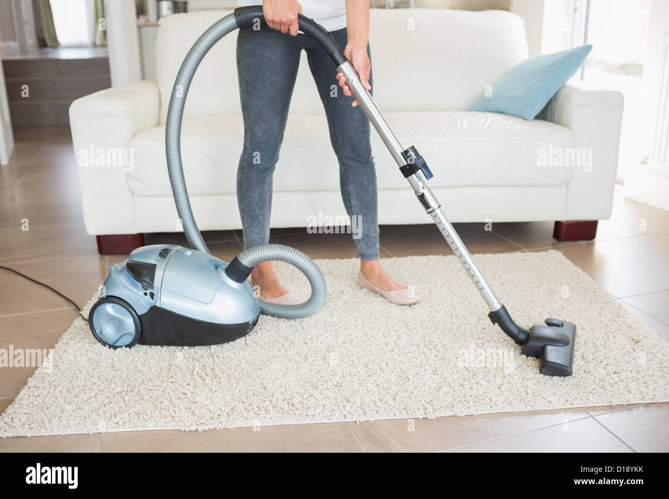 Woman hoovering rug Stock Photo - Alamy
