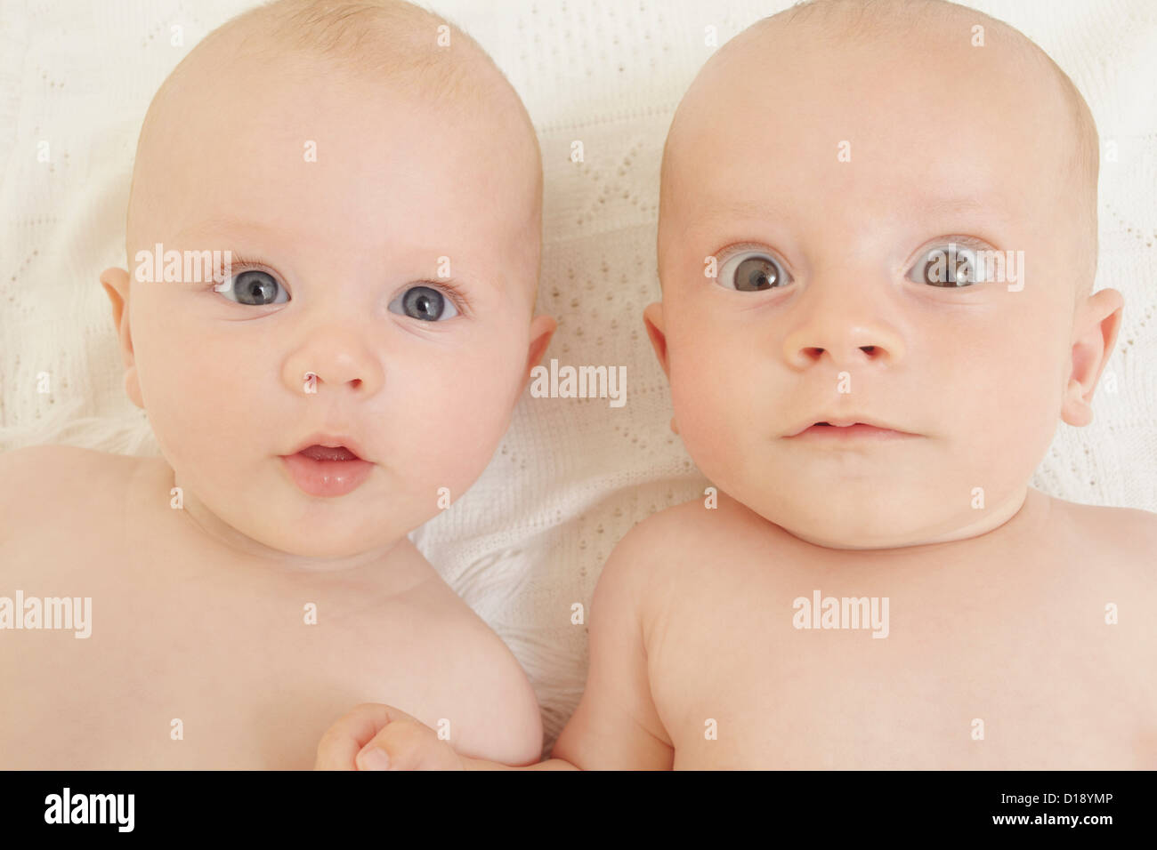 Baby boy and baby girl staring at camera Stock Photo - Alamy