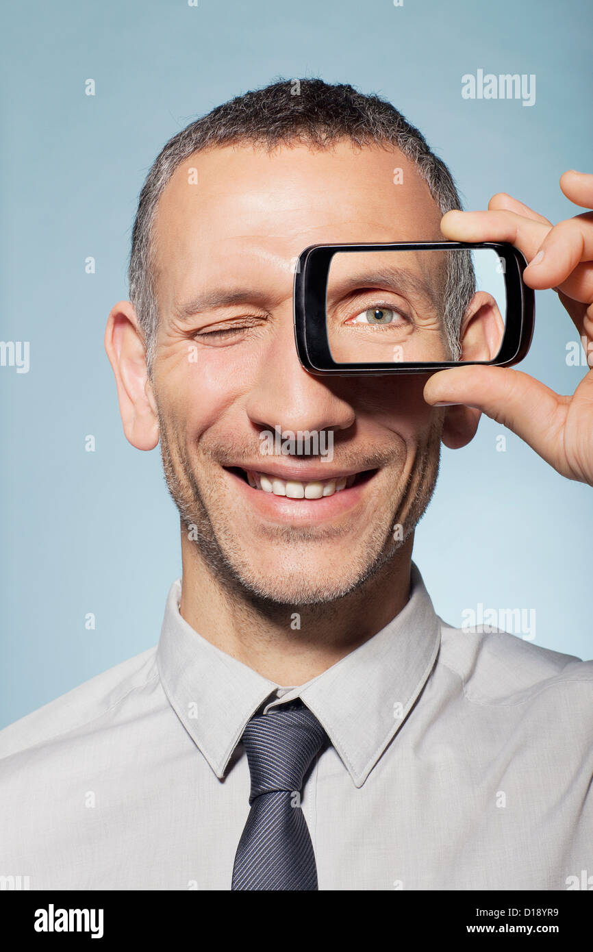Man with smartphone over eye Stock Photo - Alamy