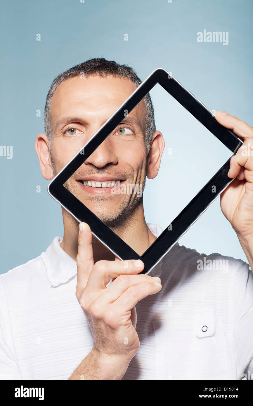 Man covering half his face with digital tablet Stock Photo - Alamy