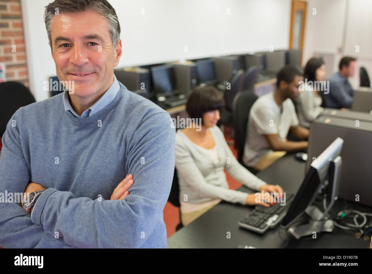 Teacher smiling at top of computer class Stock Photo - Alamy