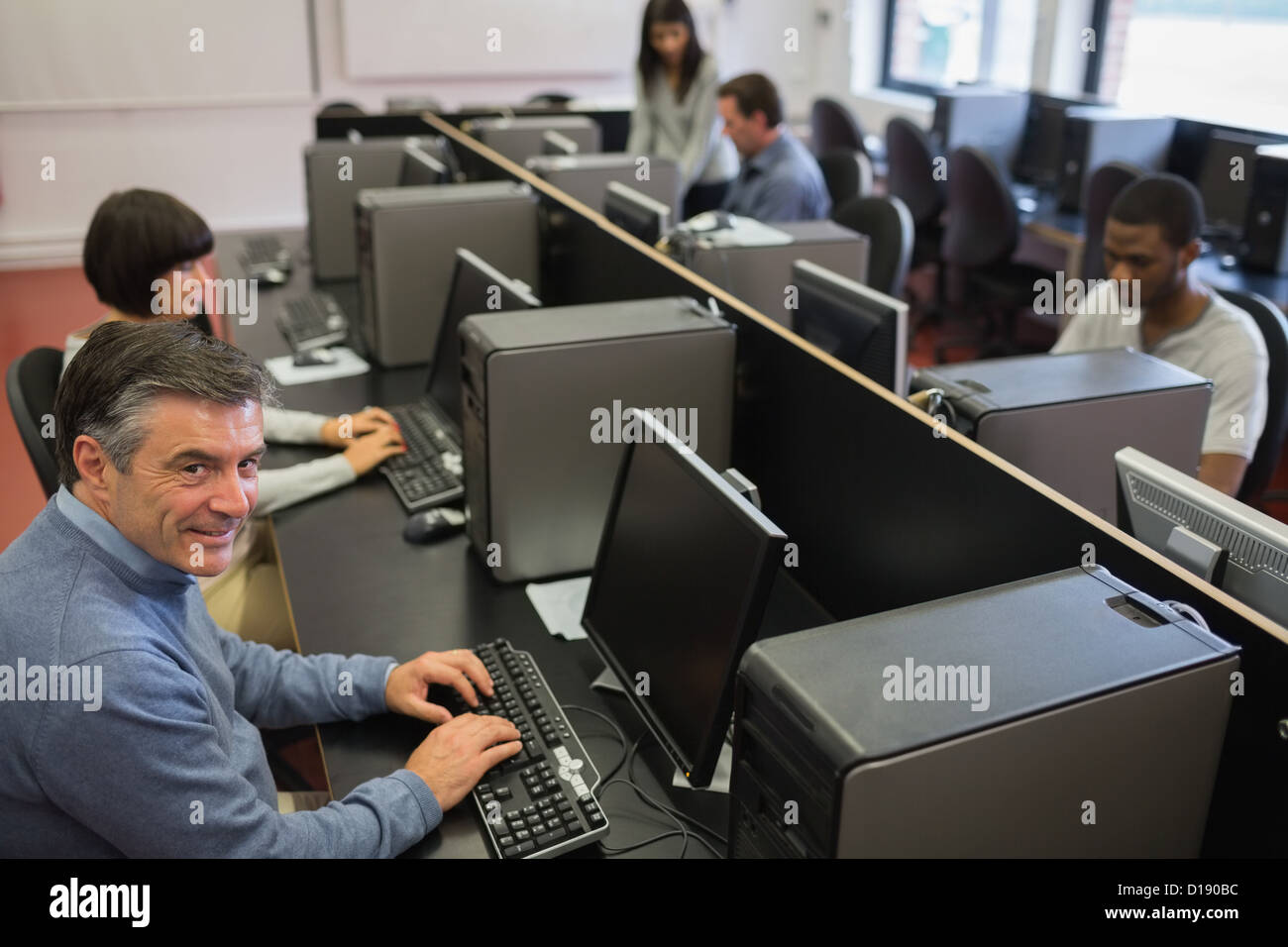 Man looking up from computer class and smiling Stock Photo - Alamy