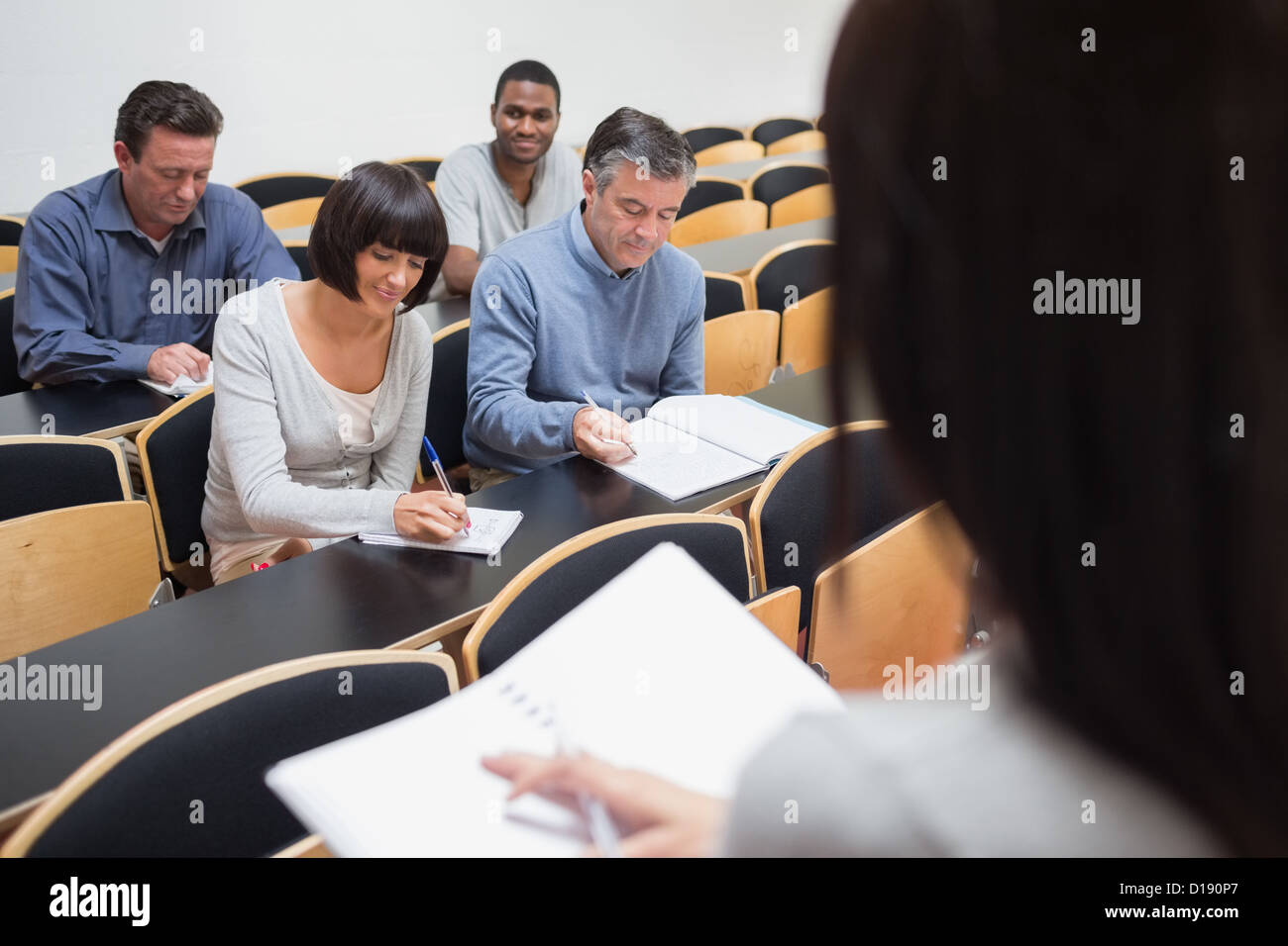 People taking notes in class Stock Photo - Alamy