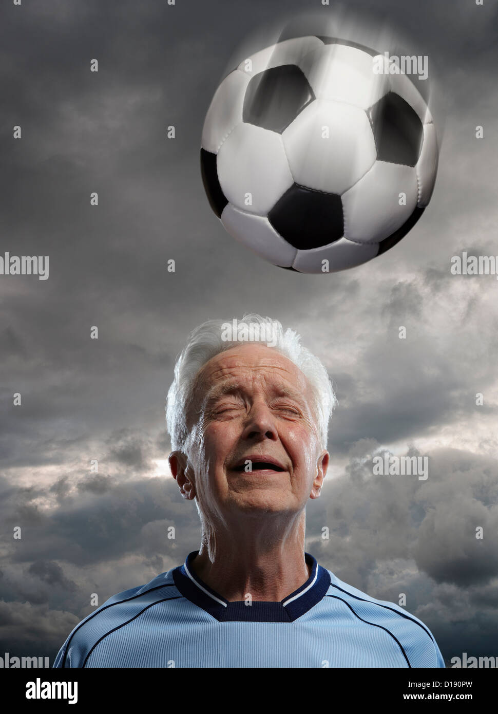 Senior man heading football Stock Photo - Alamy