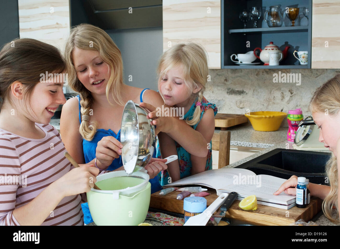 Four girls baking in kitchen Stock Photo - Alamy