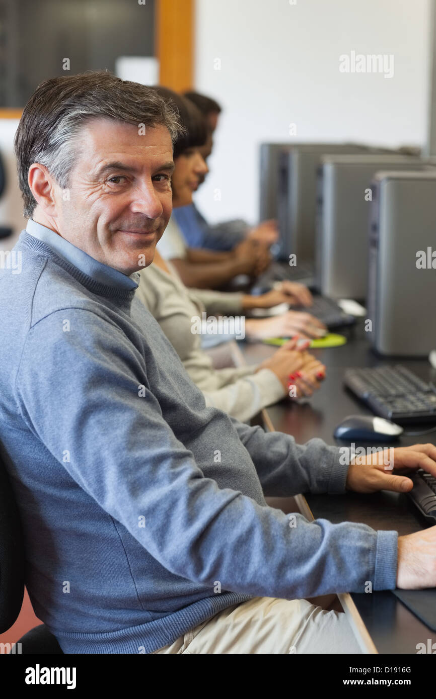 Man sitting at the computer and smiling Stock Photo - Alamy