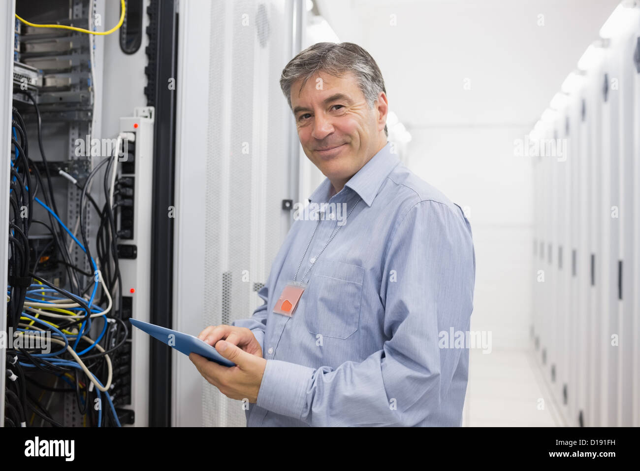 Smiling man doing maintenance on servers Stock Photo - Alamy