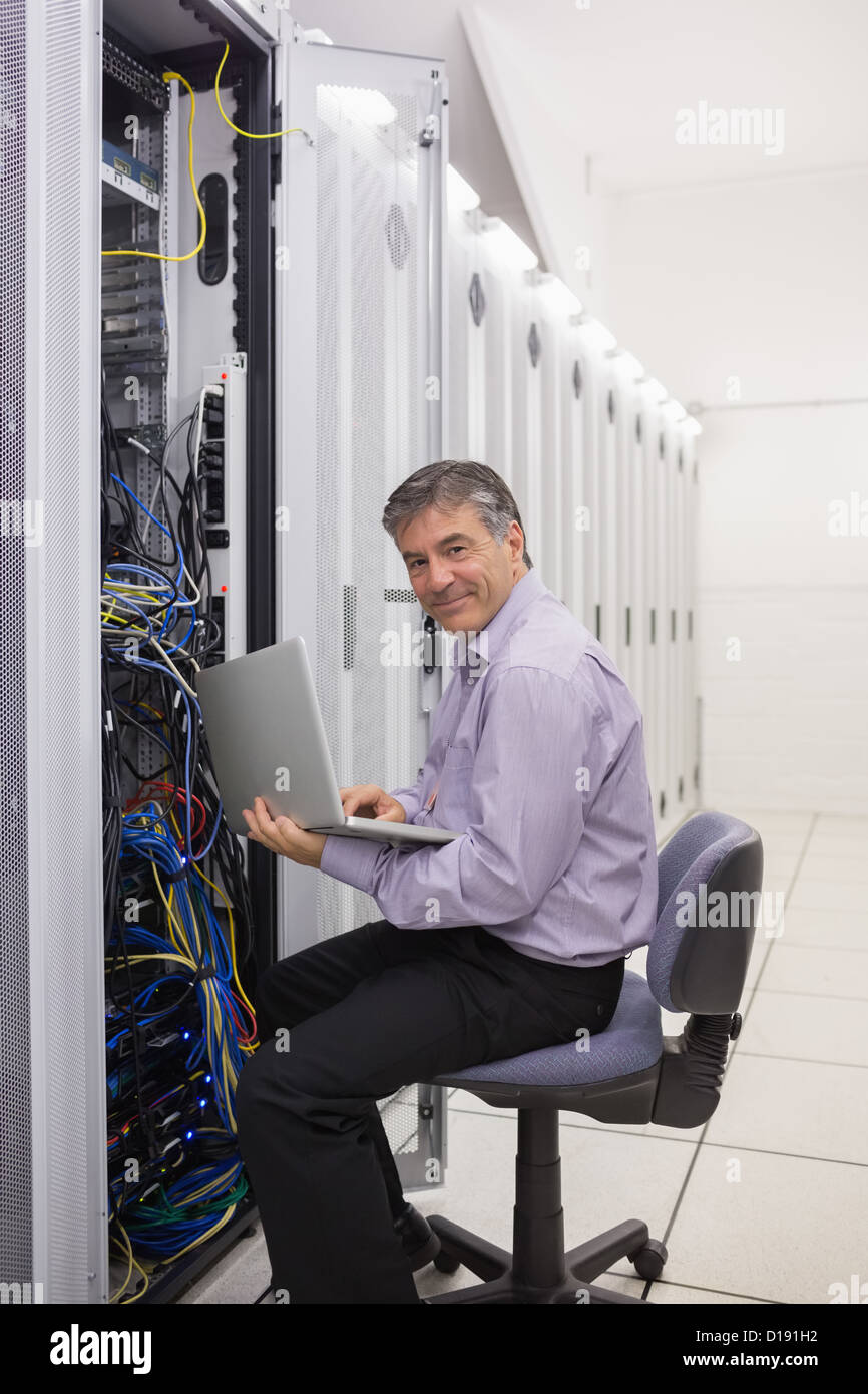 Man working on laptop to check servers Stock Photo - Alamy