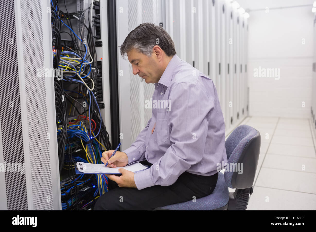 Technician writing notes on the servers Stock Photo - Alamy