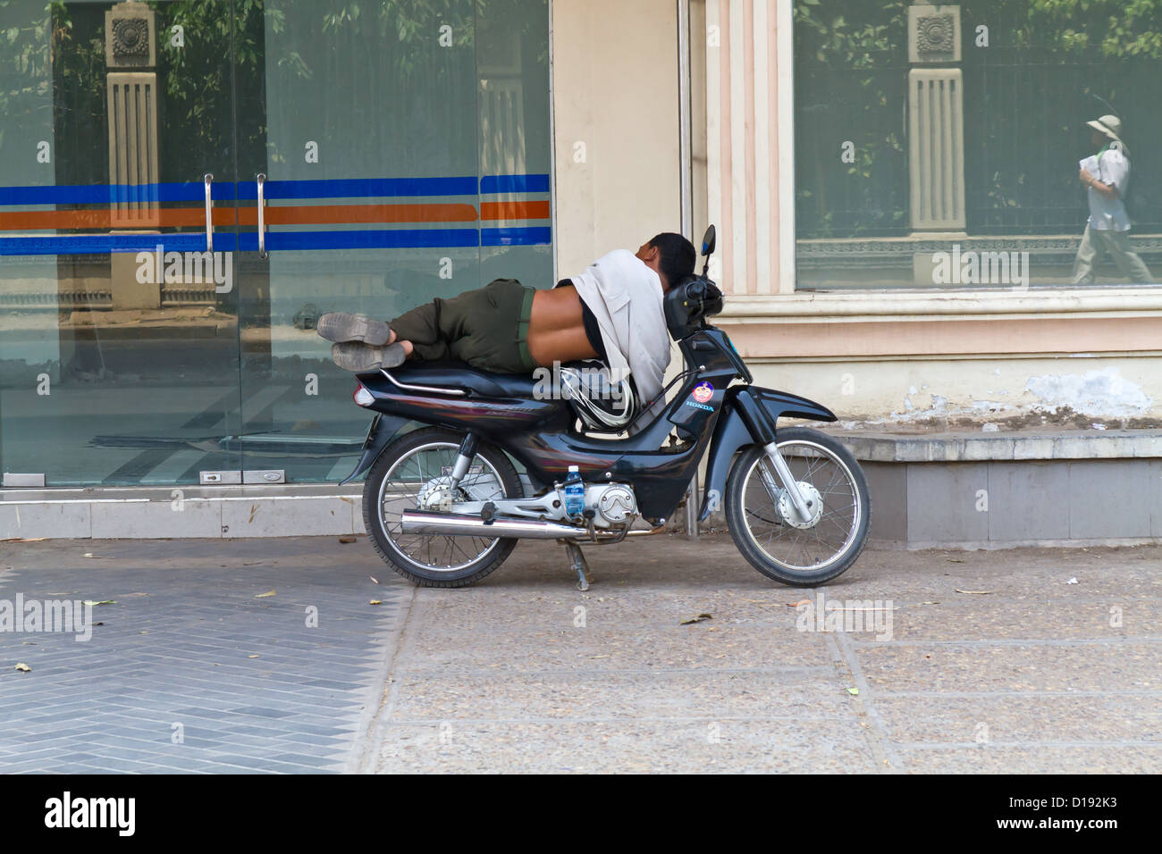 Driver sleeping on his Motorbike in the Streets of Phnom Penh, Cambodia ...