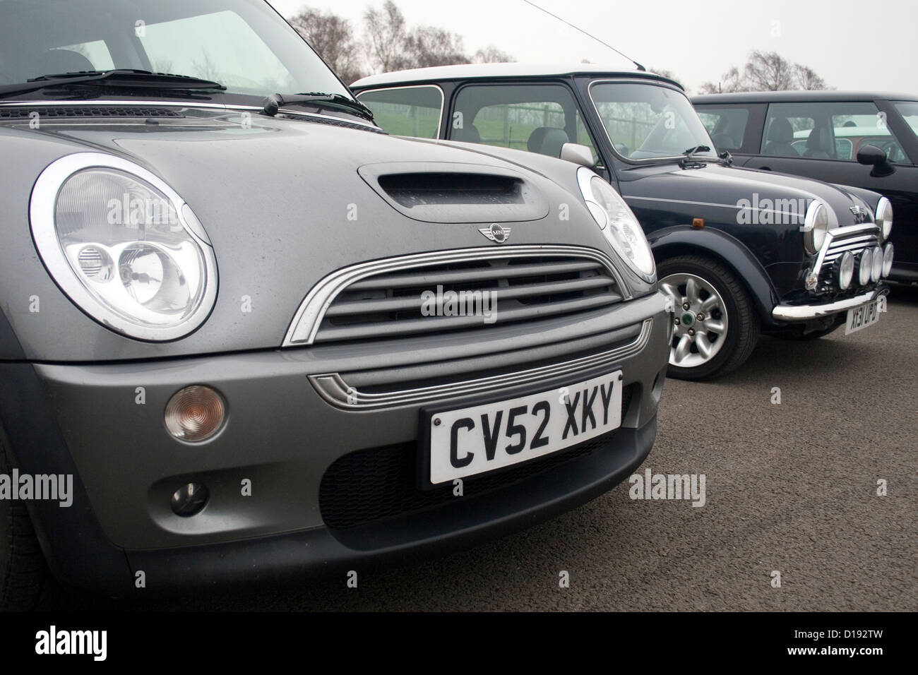 A modern new Mini car parked next to the original classic mini at a ...