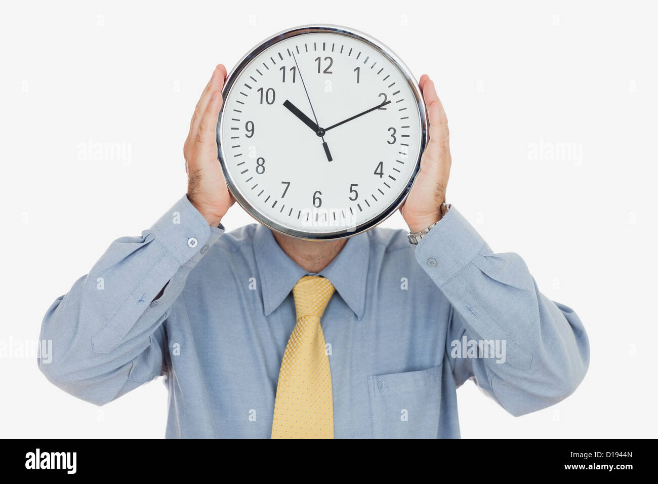 Businessman holding clock in front of face Stock Photo - Alamy