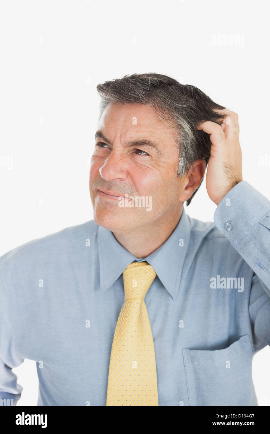 Confused businessman scratching head Stock Photo - Alamy