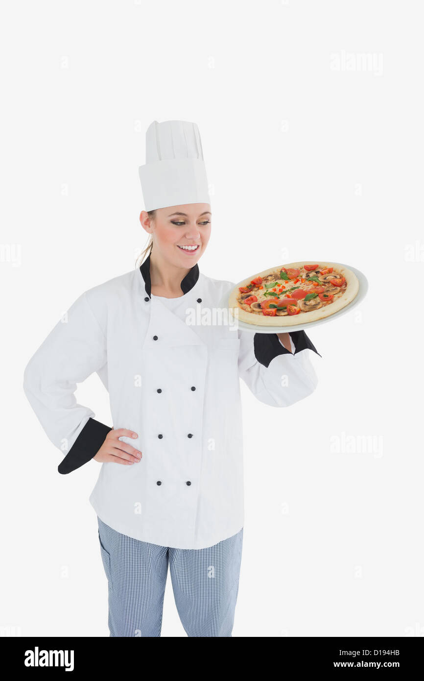 Female chef looking at pizza Stock Photo - Alamy