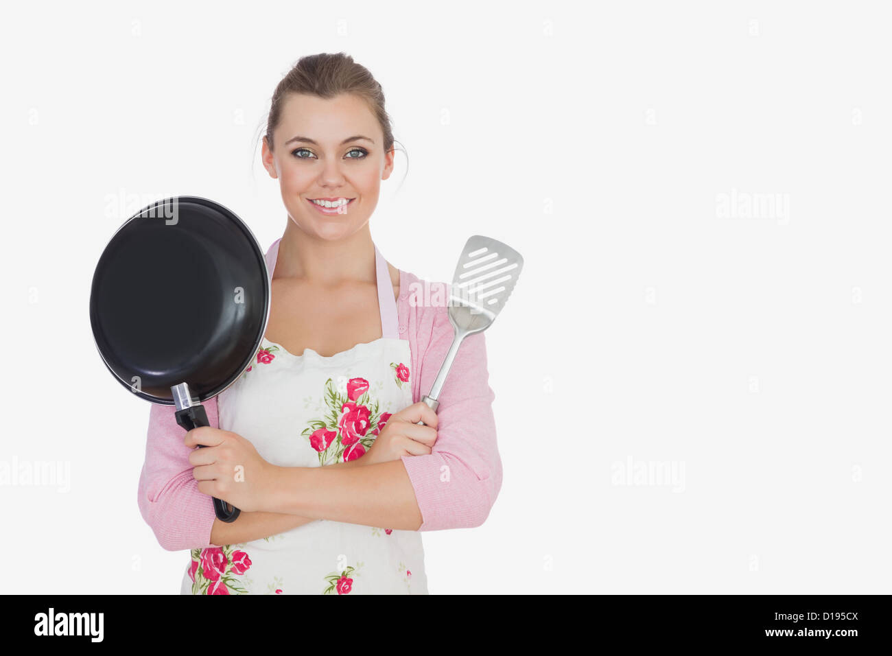 Young woman holding frying pan and spatula Stock Photo - Alamy