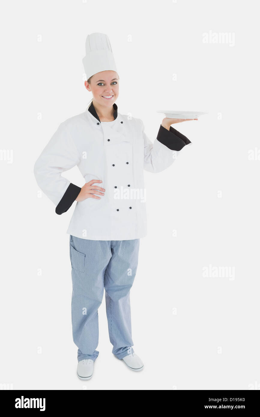 Portrait of female chef holding an empty plate Stock Photo - Alamy