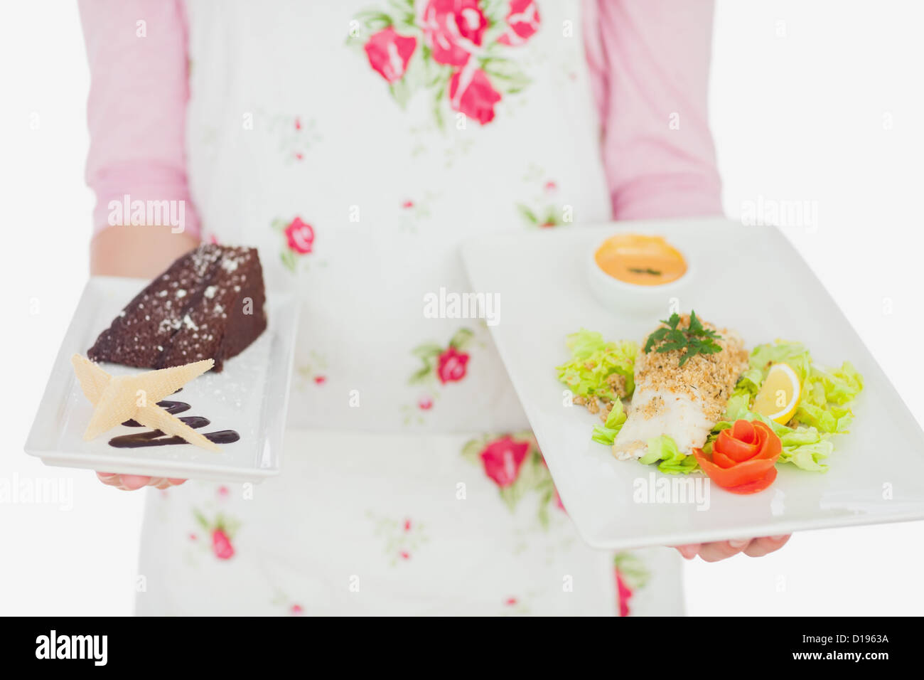 Maid holding plates of healthy meal and pastry Stock Photo - Alamy