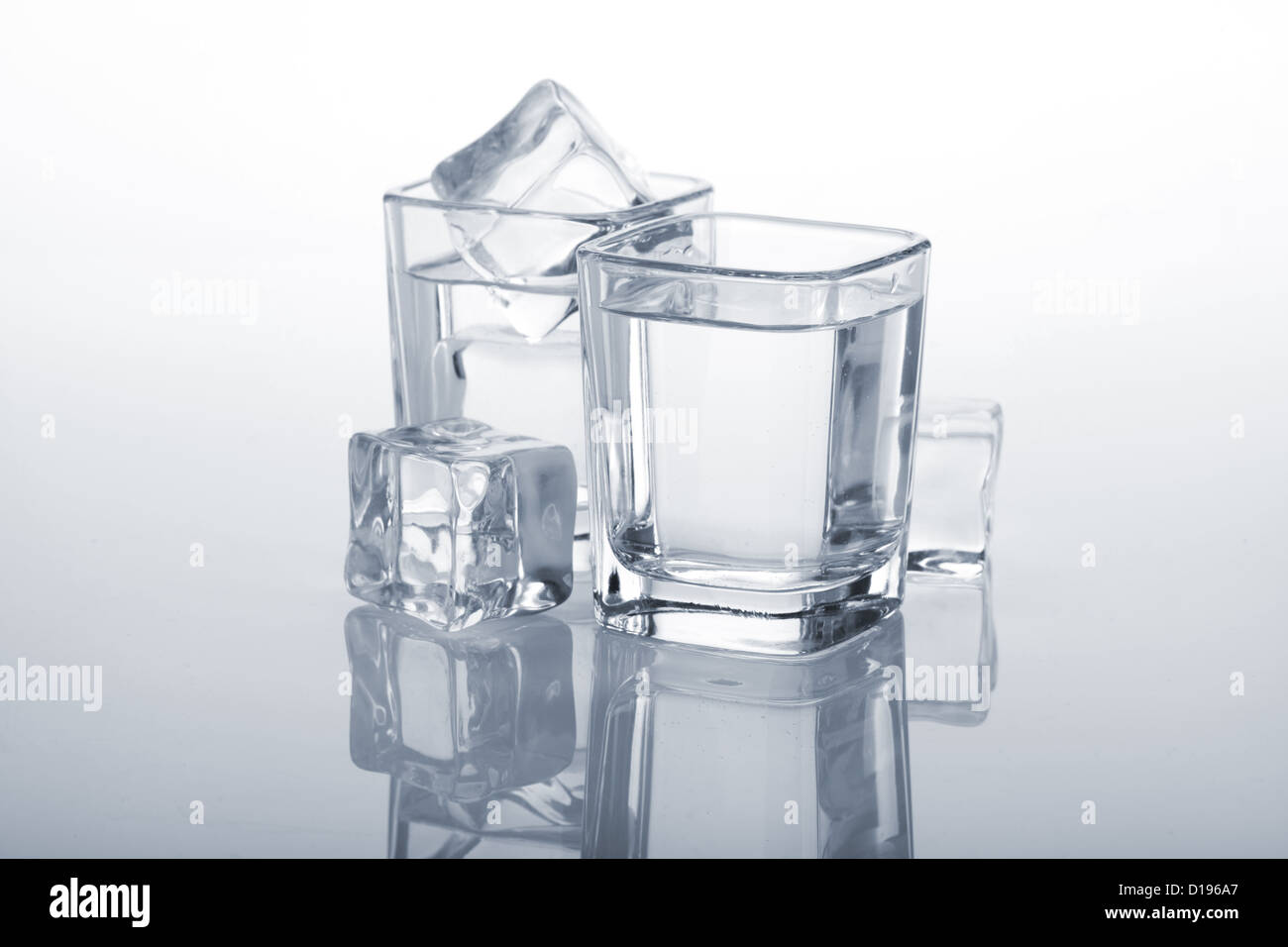 Vodka shots with ice cubes. Blue toned Stock Photo - Alamy