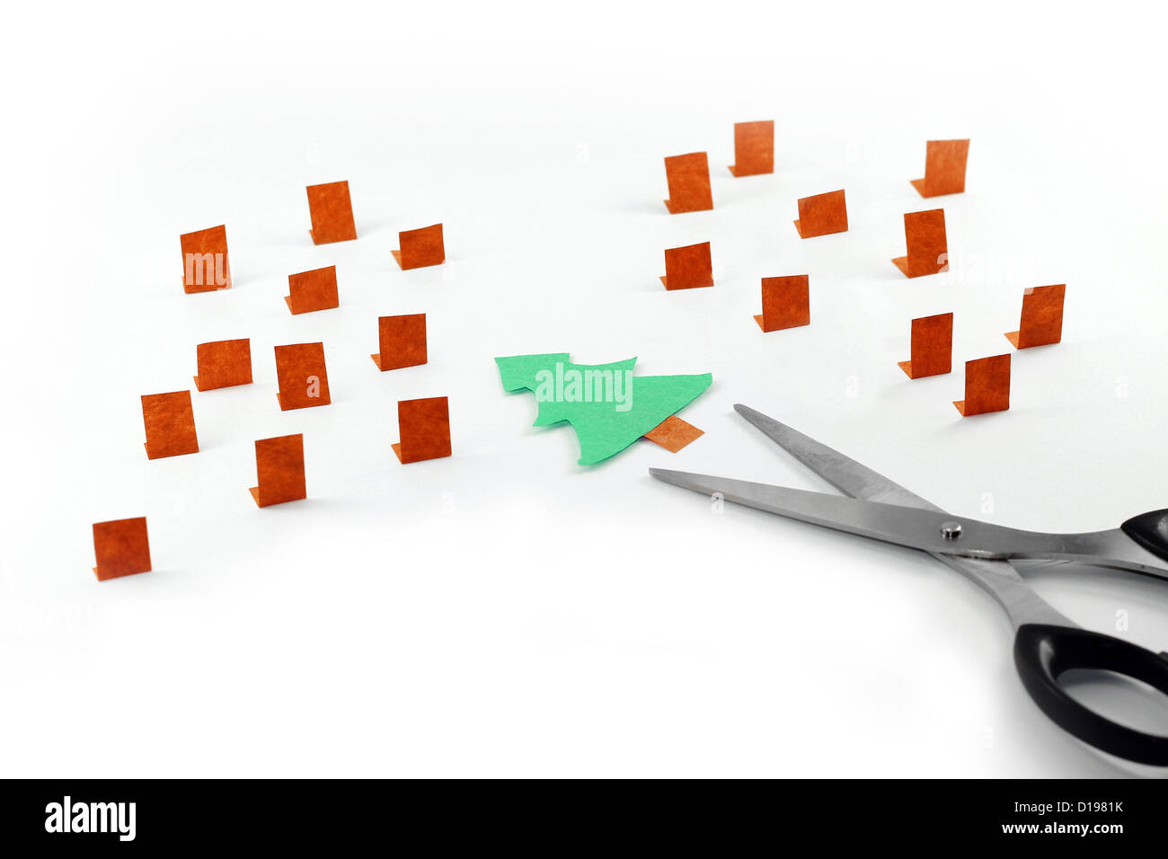 Small paper tree cut by opened scissors with already destroyed forest ...