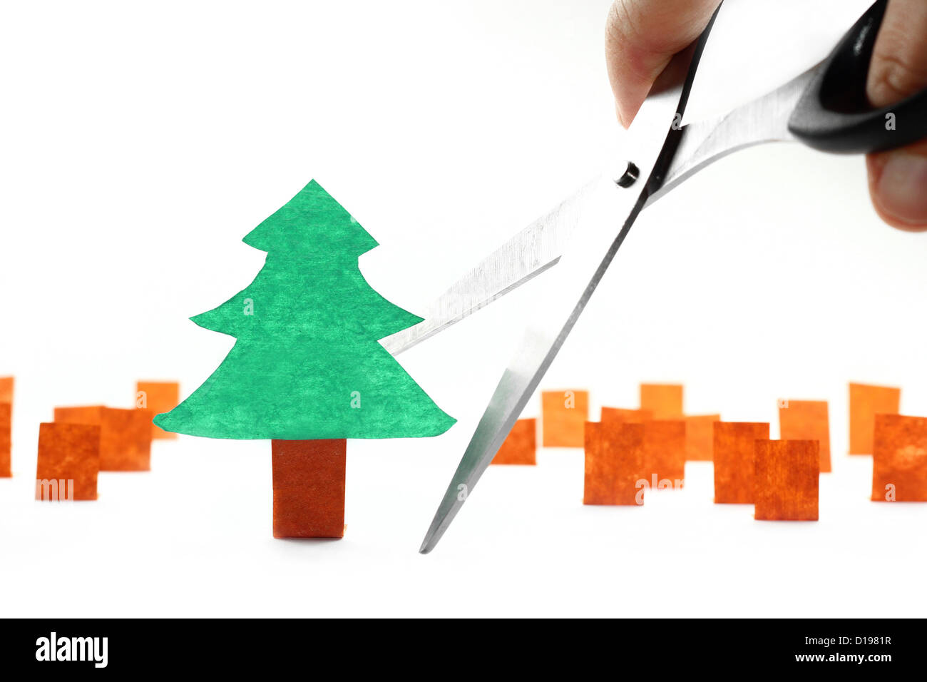 Small paper tree cut by opened scissors with already destroyed forest ...