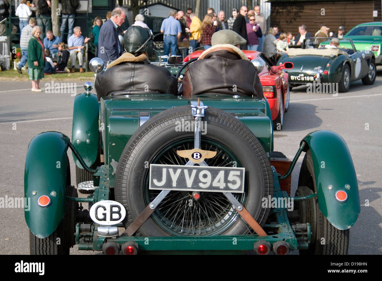 The back of a vintage Bentley car being driven away from a car show ...