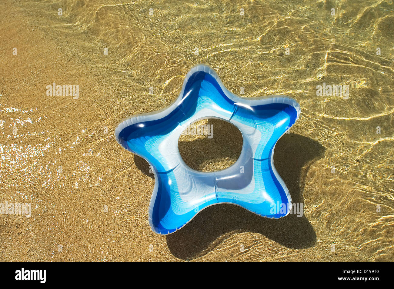 Blue And White Star Swim Ring In Shallow Water Stock Photo - Alamy