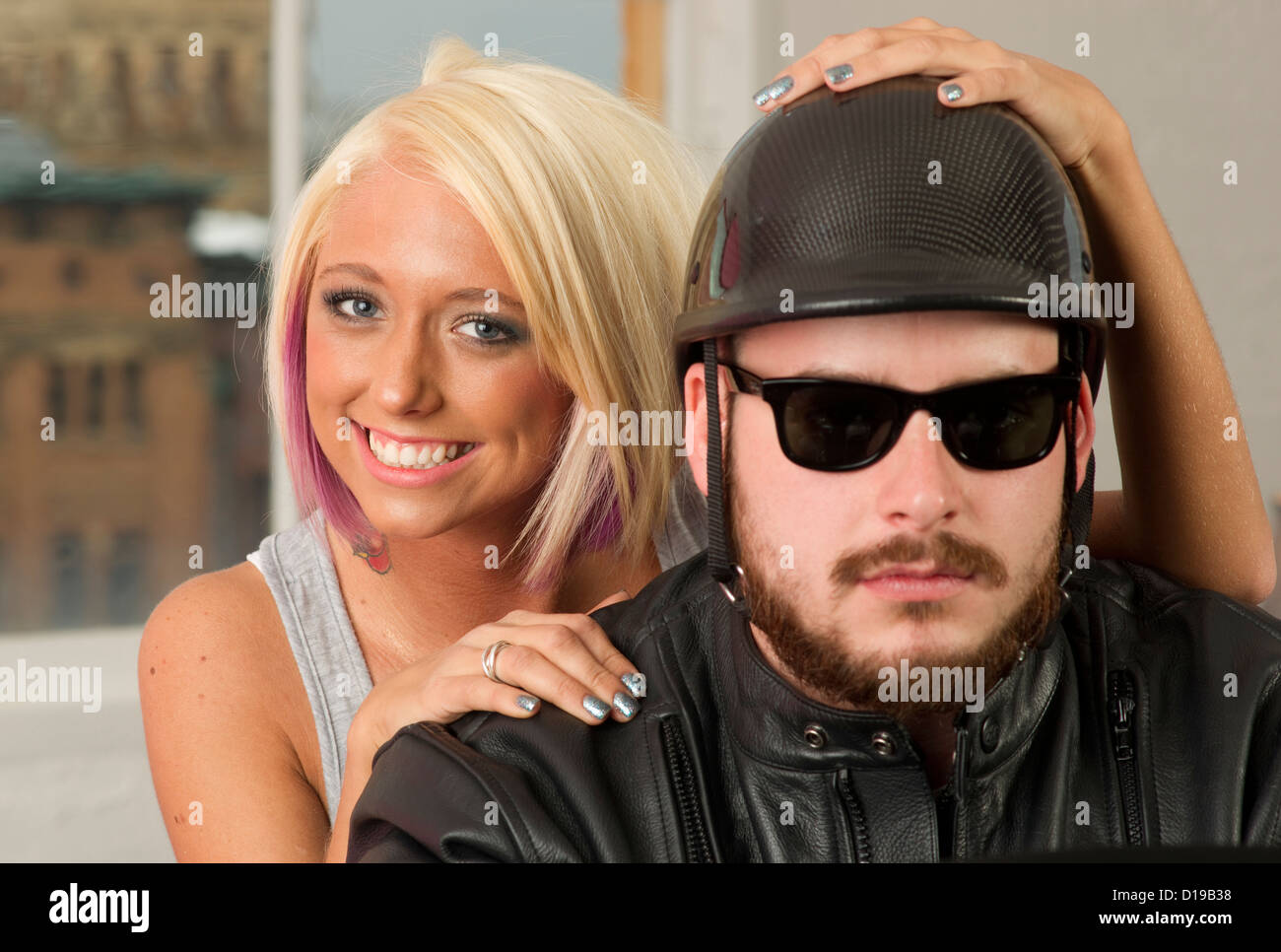 Woman on the back of the motorcycle smiles as she pokes her driver ...