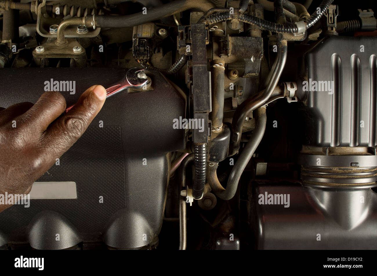 South African or American mechanic hand with spanner fixing or ...