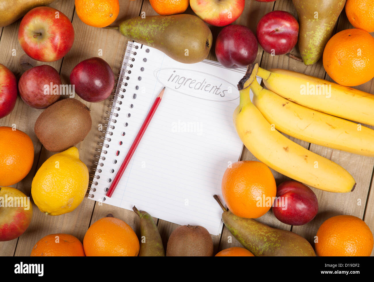 Pencil on book amidst fruits Stock Photo - Alamy