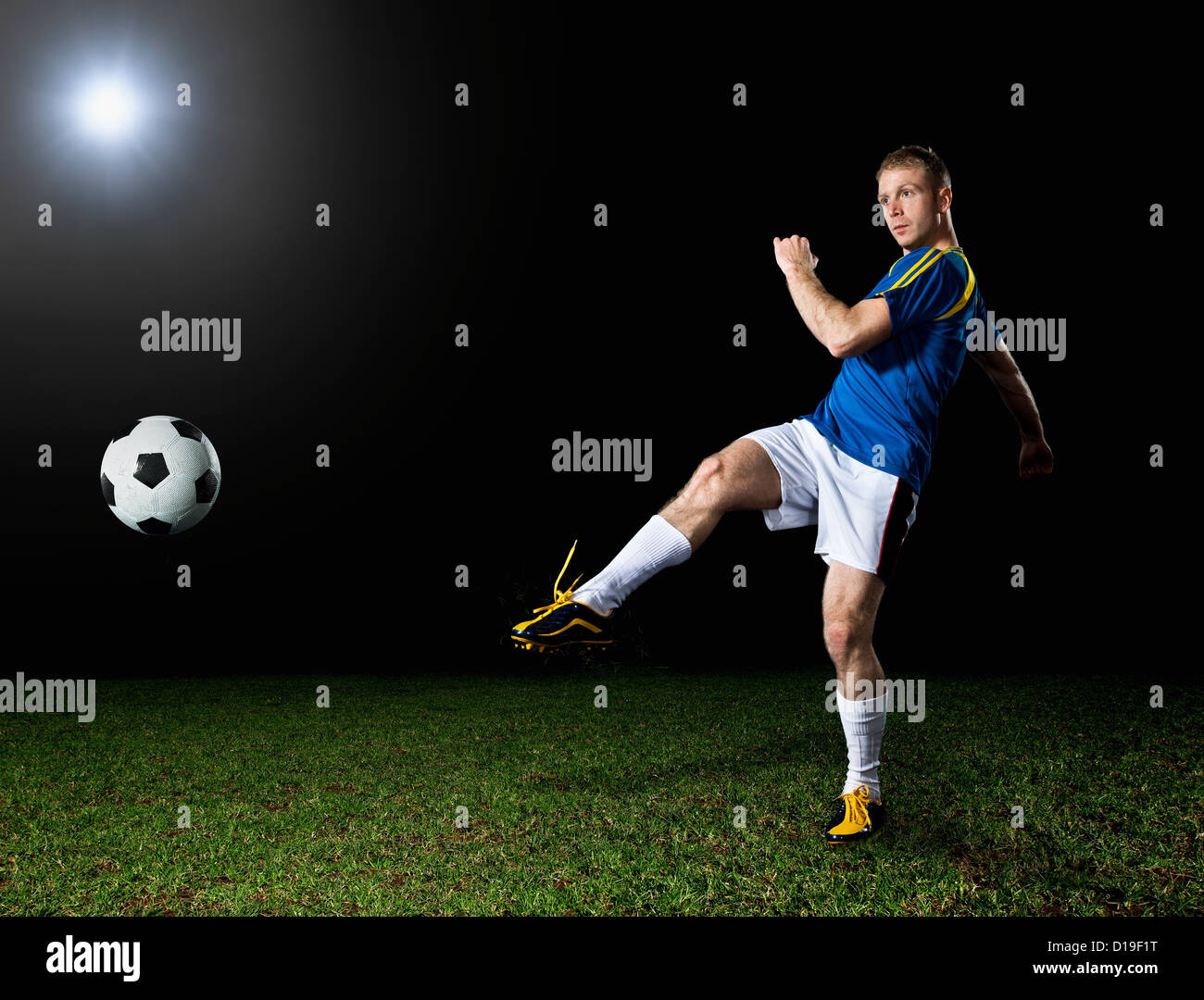 Soccer player kicking ball Stock Photo - Alamy