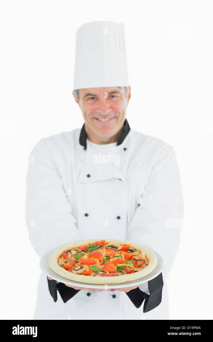 Happy chef offering pizza Stock Photo - Alamy