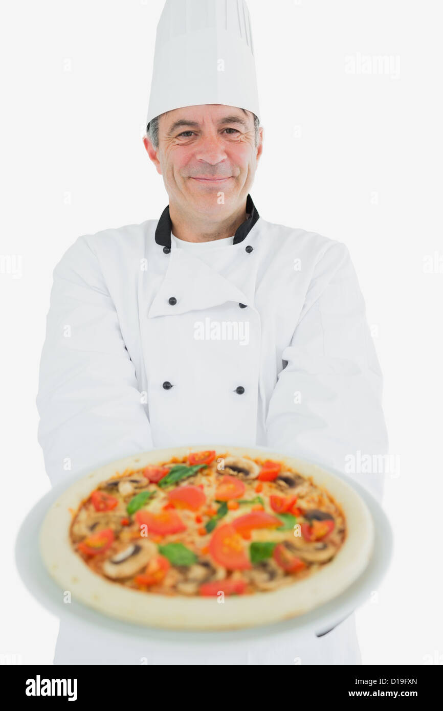 Happy chef offering pizza Stock Photo - Alamy