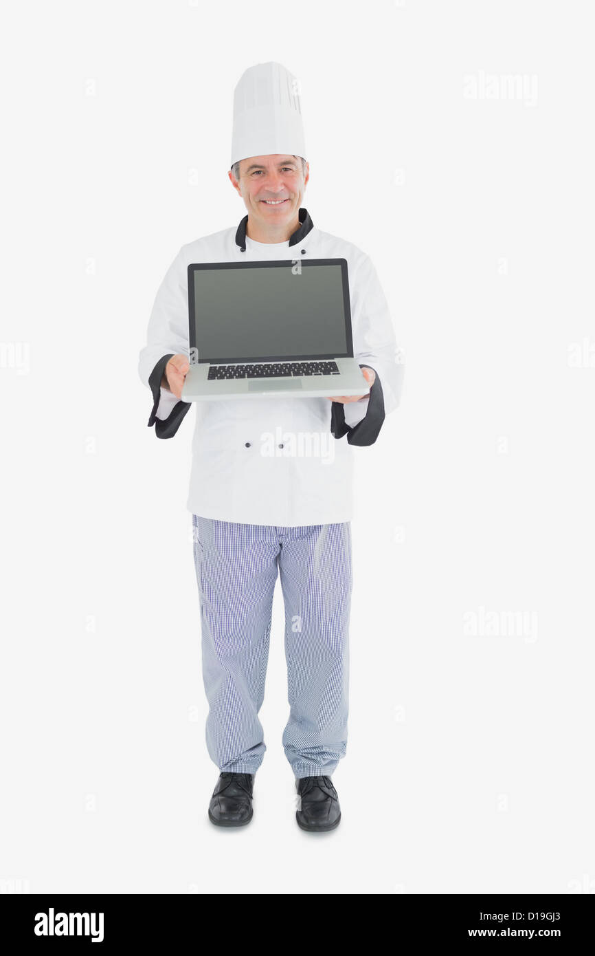 Happy male chef displaying laptop Stock Photo - Alamy