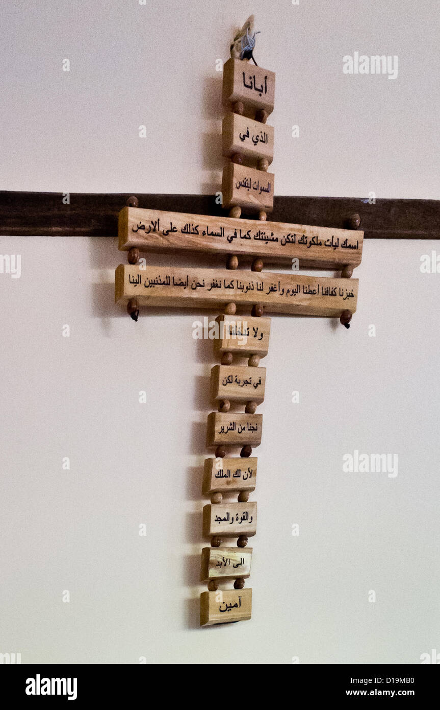A cross with Arabic inscriptions hangs on a wall in the home of the ...