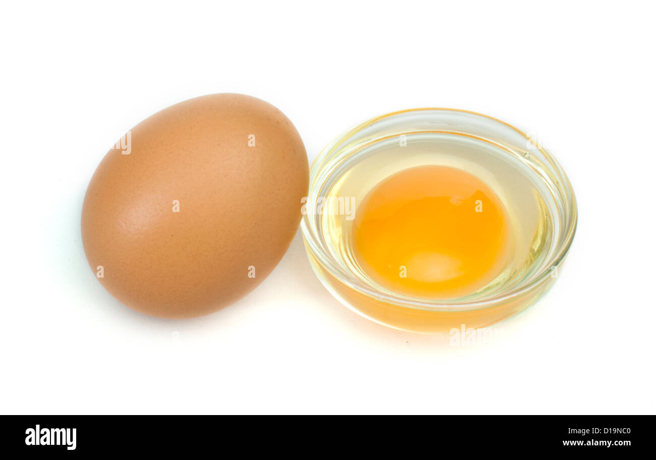 One whole egg and another broken in half raw egg and yolk inside ...