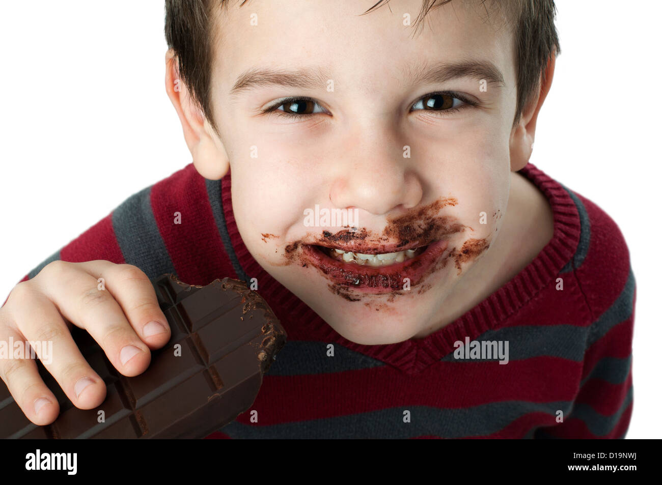 Smiling kid eating chocolate. Smeared stained with chocolate lips ...