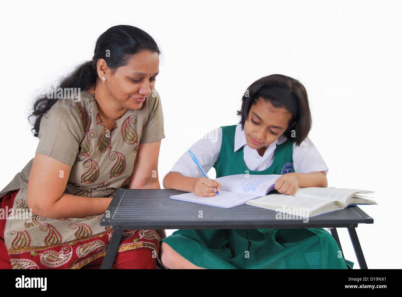 Mother teaching her daughter in school uniform Stock Photo - Alamy