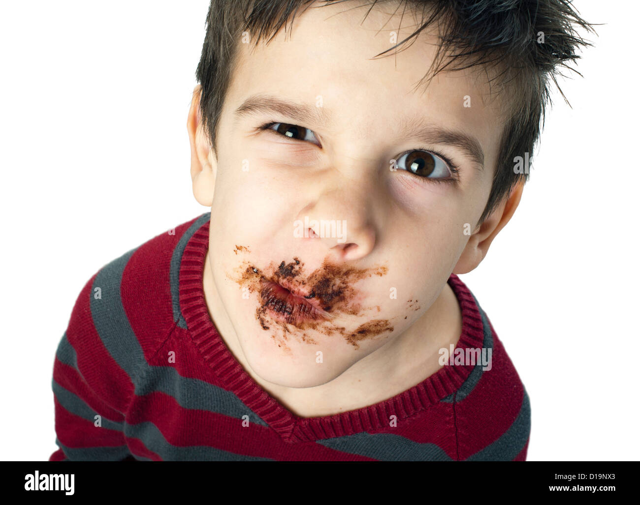 Smiling kid eating chocolate. Smeared stained with chocolate lips ...