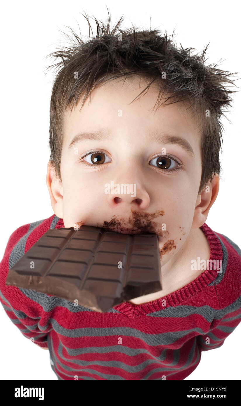 Smiling kid eating chocolate. Smeared stained with chocolate lips ...