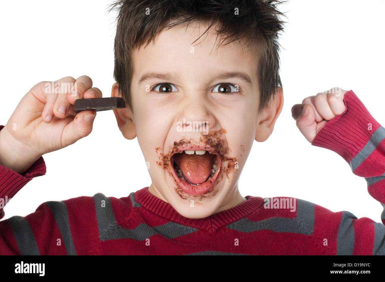 Smiling kid eating chocolate. Smeared stained with chocolate lips ...