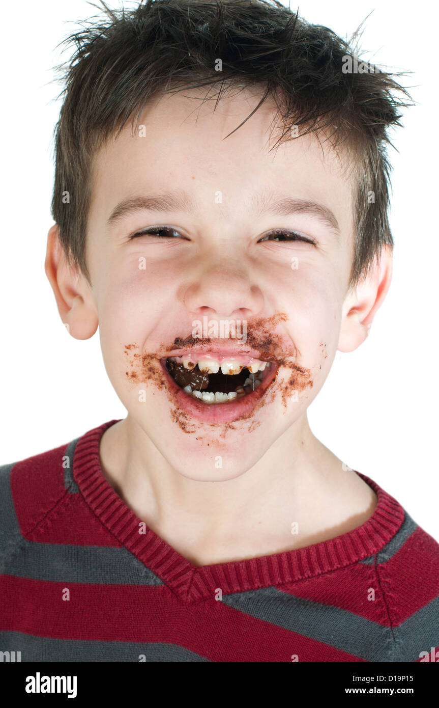 Smiling kid eating chocolate. Smeared stained with chocolate lips ...